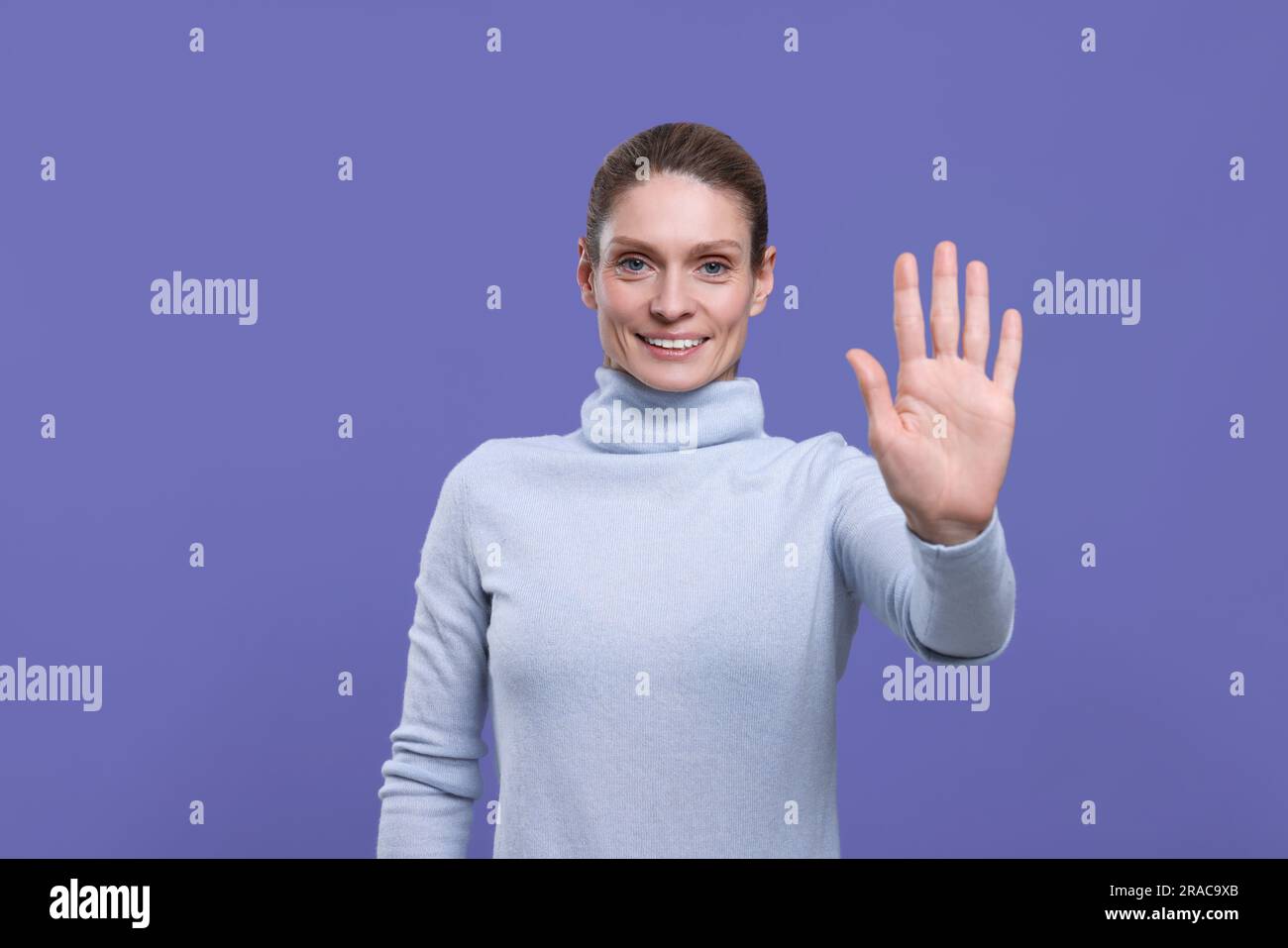 Woman giving high five on purple background Stock Photo - Alamy