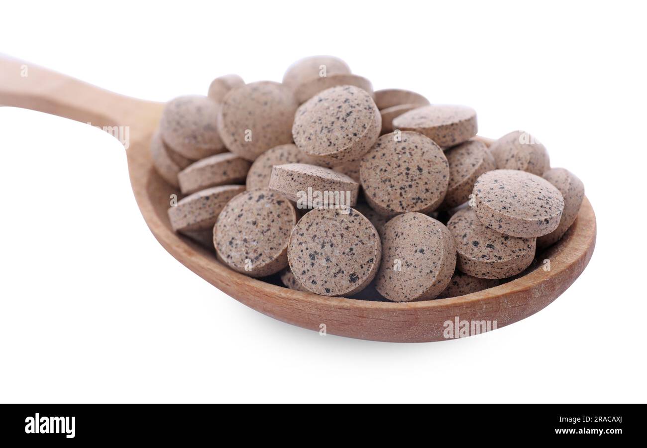 Brewer's yeast tablets in spoon on white background Stock Photo - Alamy