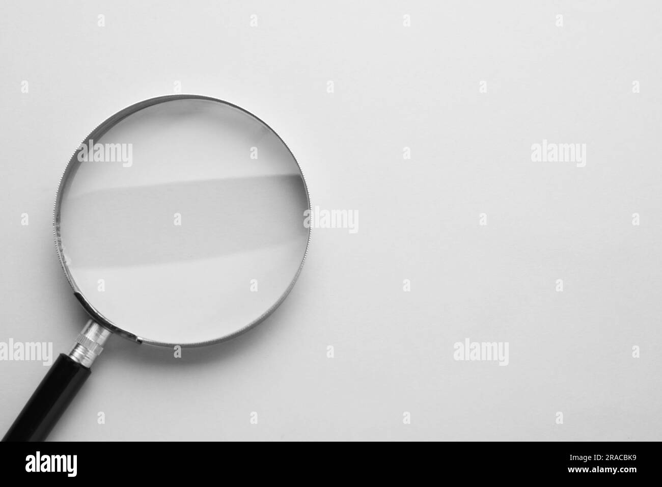 Magnifying glass on light grey background, top view. Space for text ...