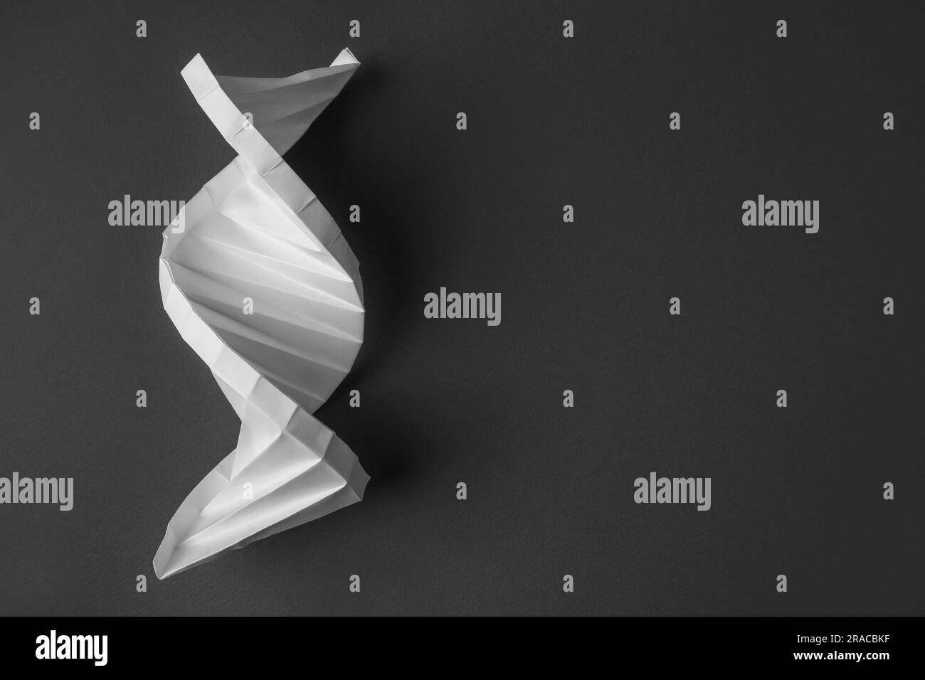 Paper model of DNA molecular chain on black background, top view. Space ...