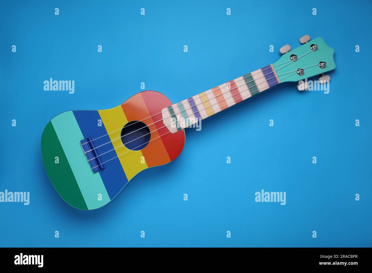 Colorful ukulele on light blue background, top view. String musical ...