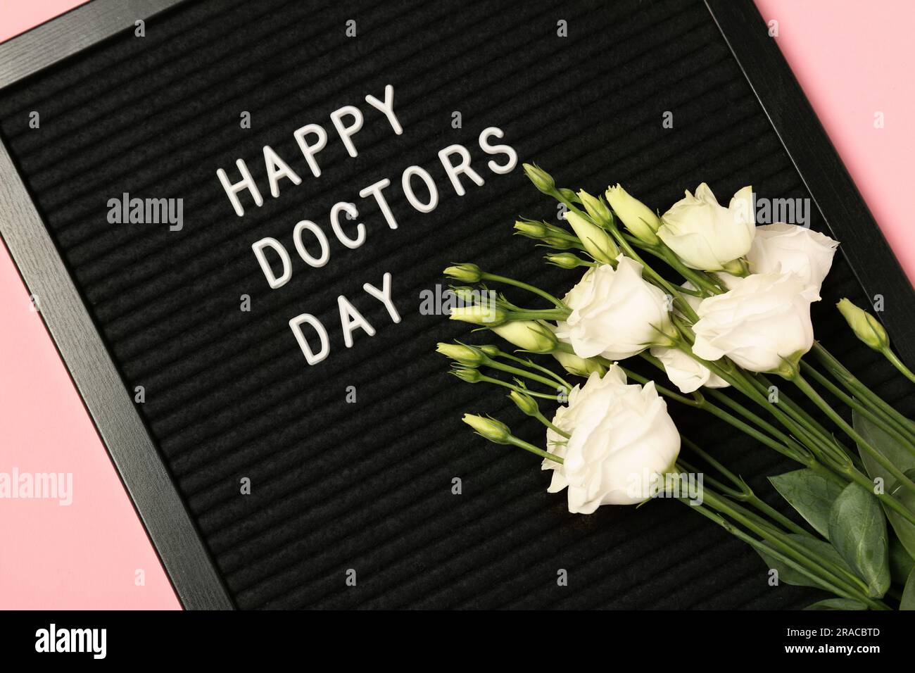 Black letter board with phrase Happy Doctor's Day and beautiful eustoma ...