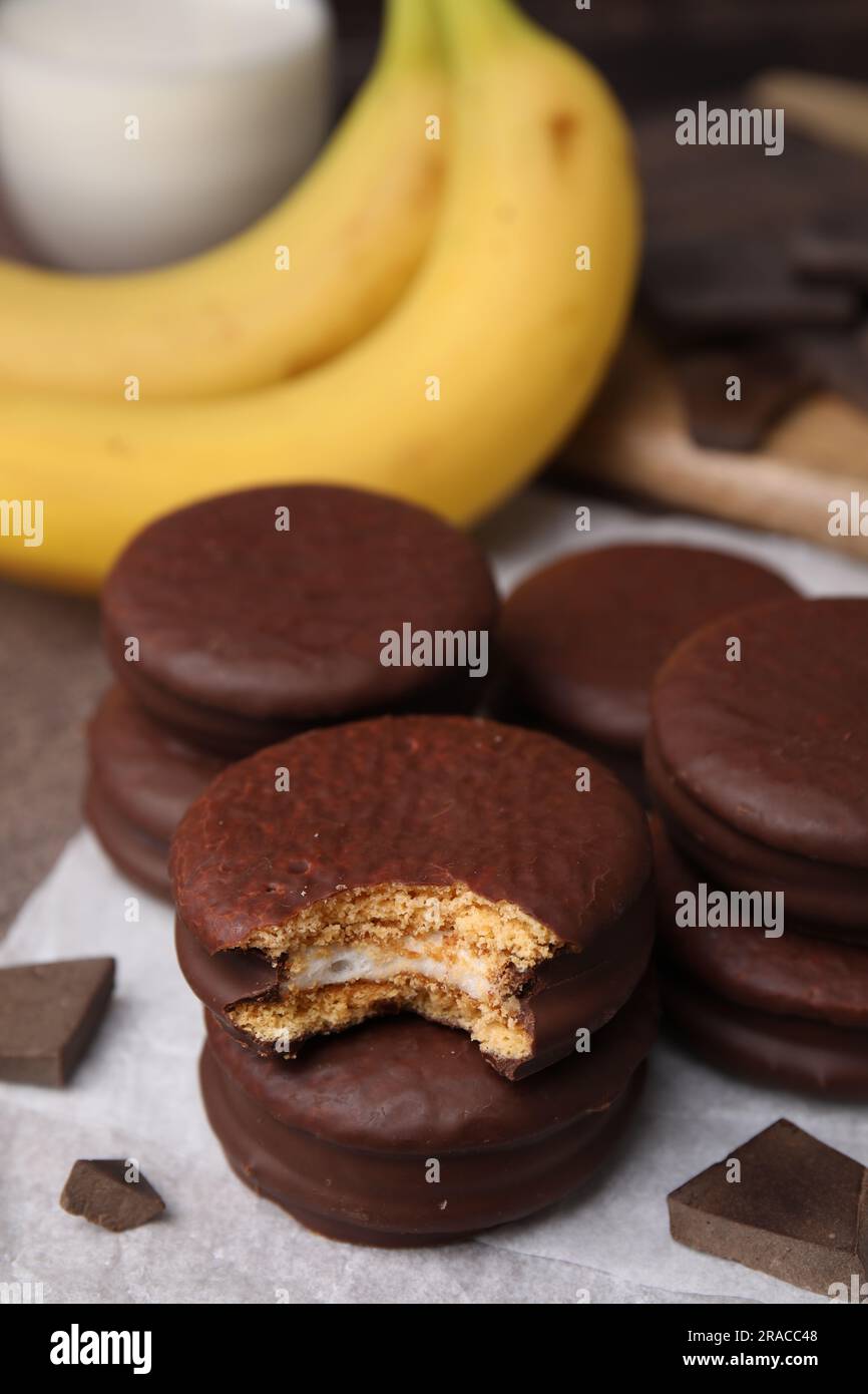Tasty banana choco pies and pieces of chocolate on parchment paper ...