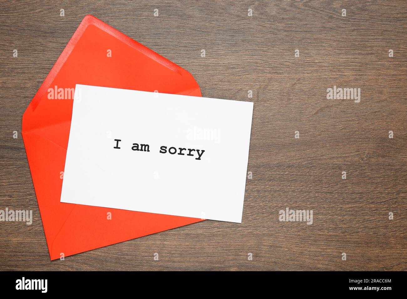Apology. Card with phrase I Am Sorry and red envelope on wooden table ...