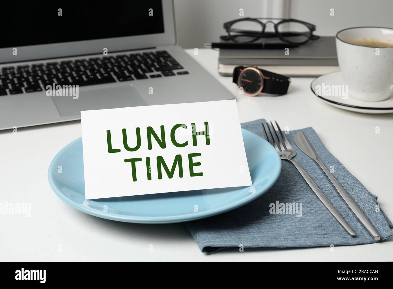 Business lunch. Office desk with plate, cutlery and laptop. Card with ...