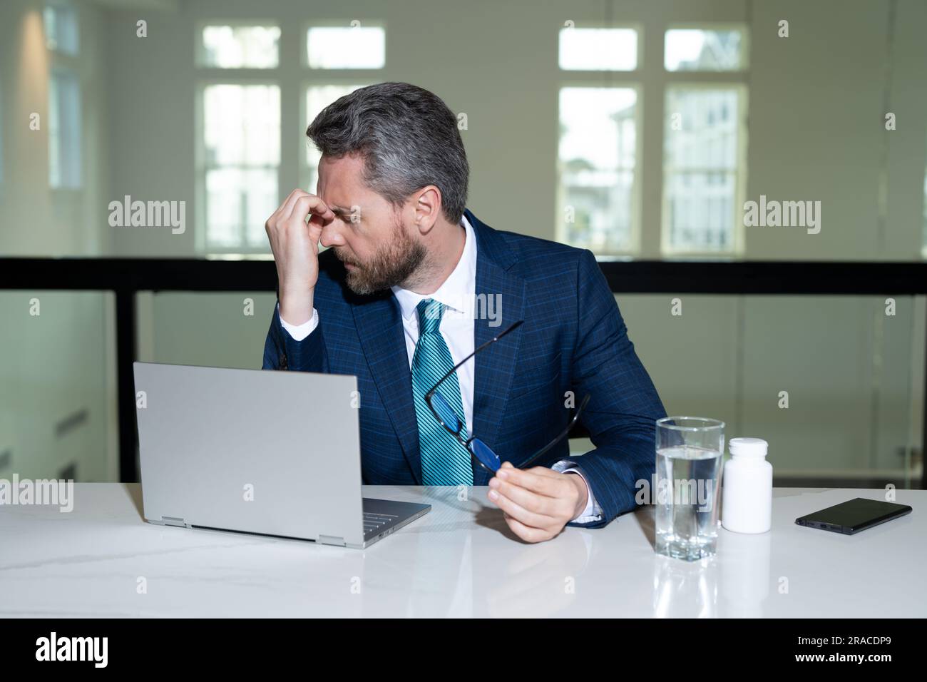 Stressed business man having headache at office. Tired businessman is ...