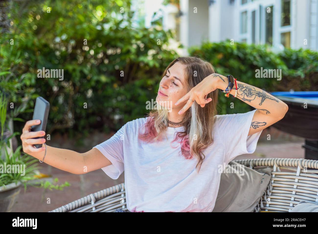 Cute woman taking a photo selfie and drinking tea in summer garden ...