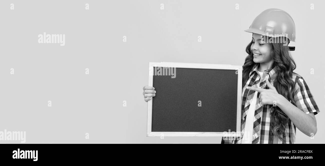 happy teen girl in helmet pointing finger on school blackboard with ...