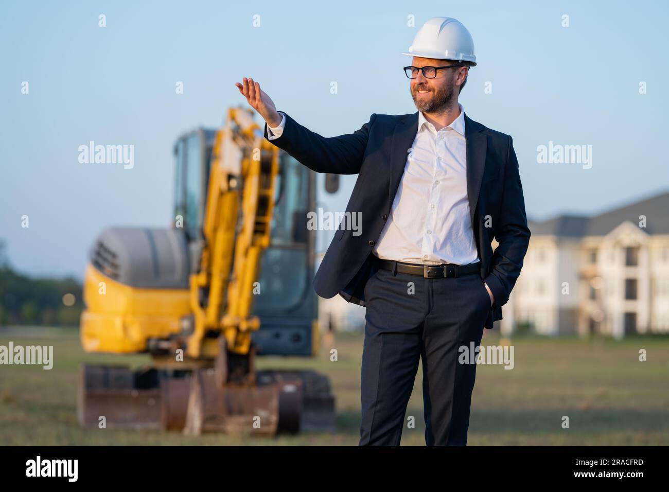 Architect at a construction site. Architect man in helmet and suit at ...