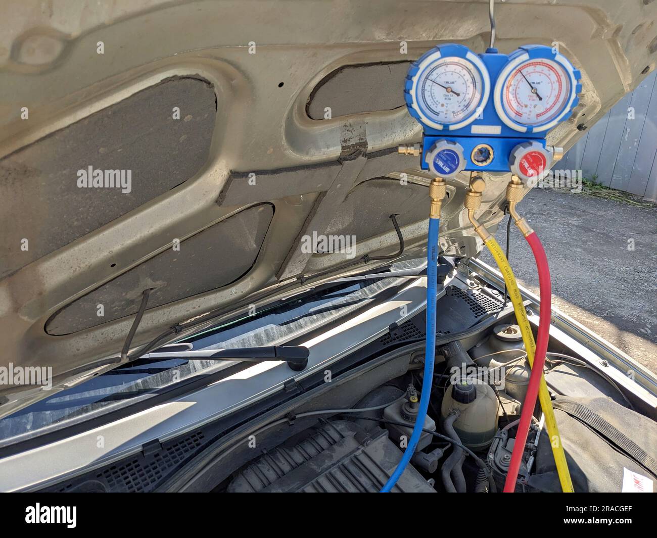 Refueling a car air conditioner with freon Stock Photo - Alamy