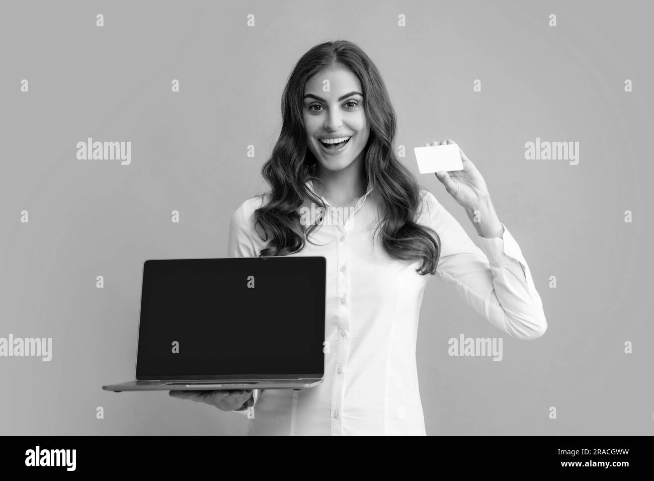 Happy brunette woman with laptop computer while holding credit card ...