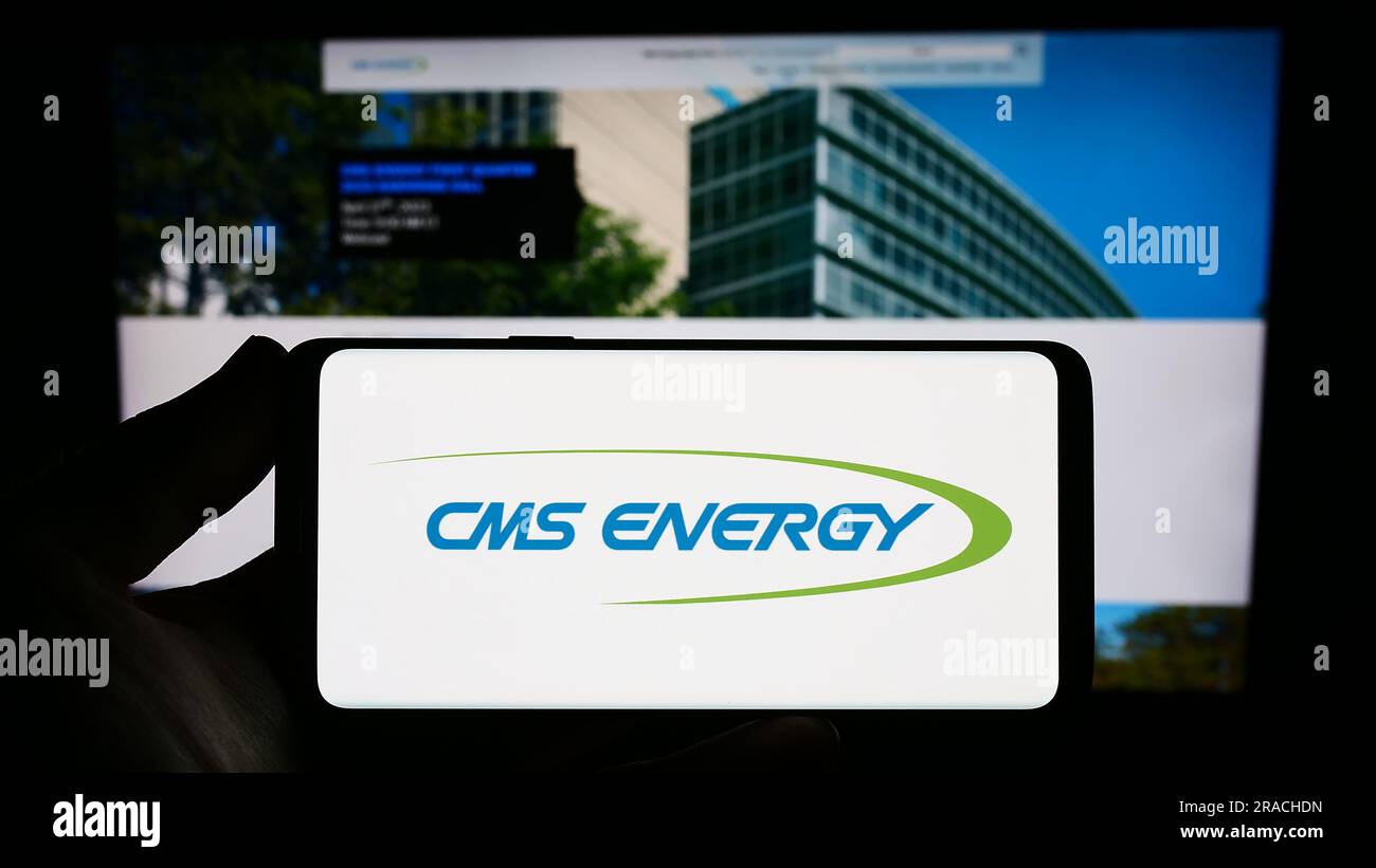 Person holding smartphone with logo of US utility company CMS Energy ...