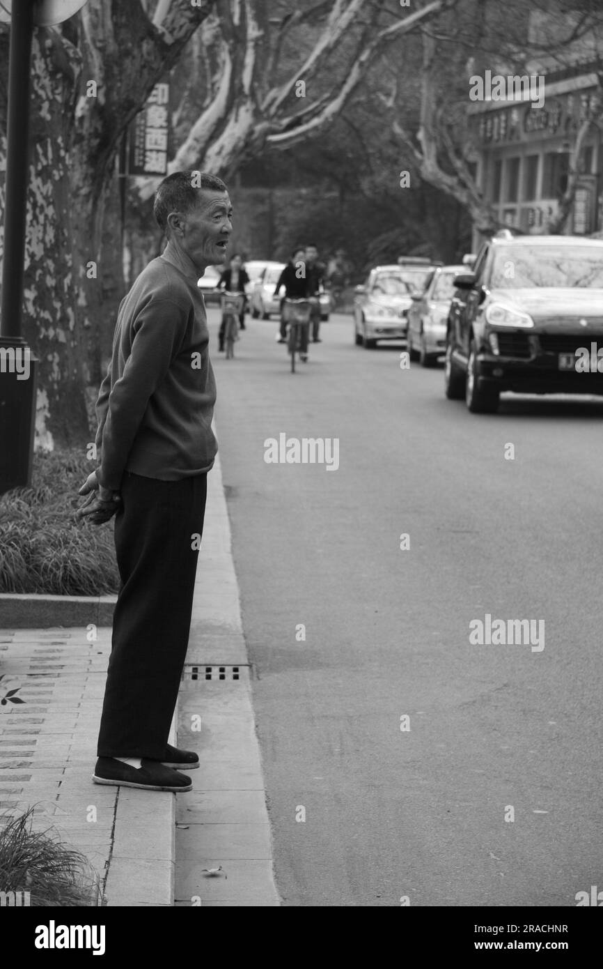 Man Watching Traffic Pass on Beishan Street in Hangzhou China Stock ...