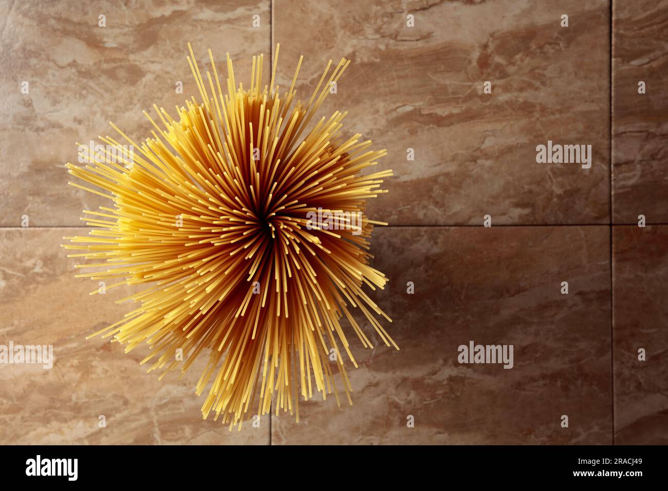 Yellow long spaghetti on a brown ceramic background. Yellow Italian ...
