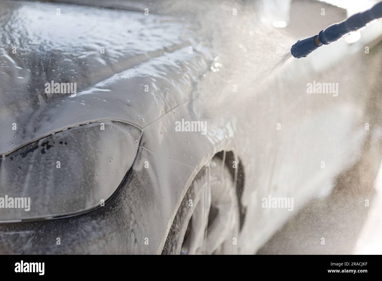 Worker washing car at self-service car wash Stock Photo - Alamy