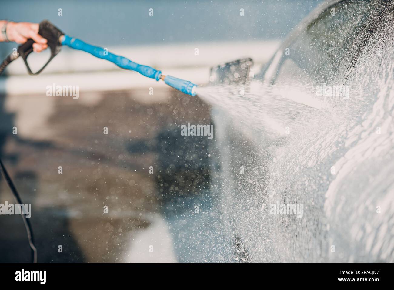 Worker washing car at self-service car wash Stock Photo - Alamy