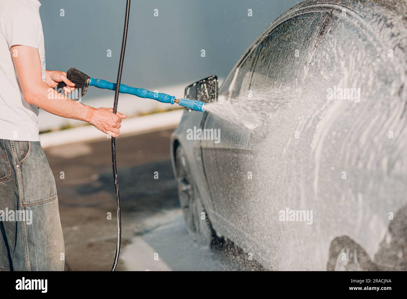 Worker washing car at self-service car wash Stock Photo - Alamy
