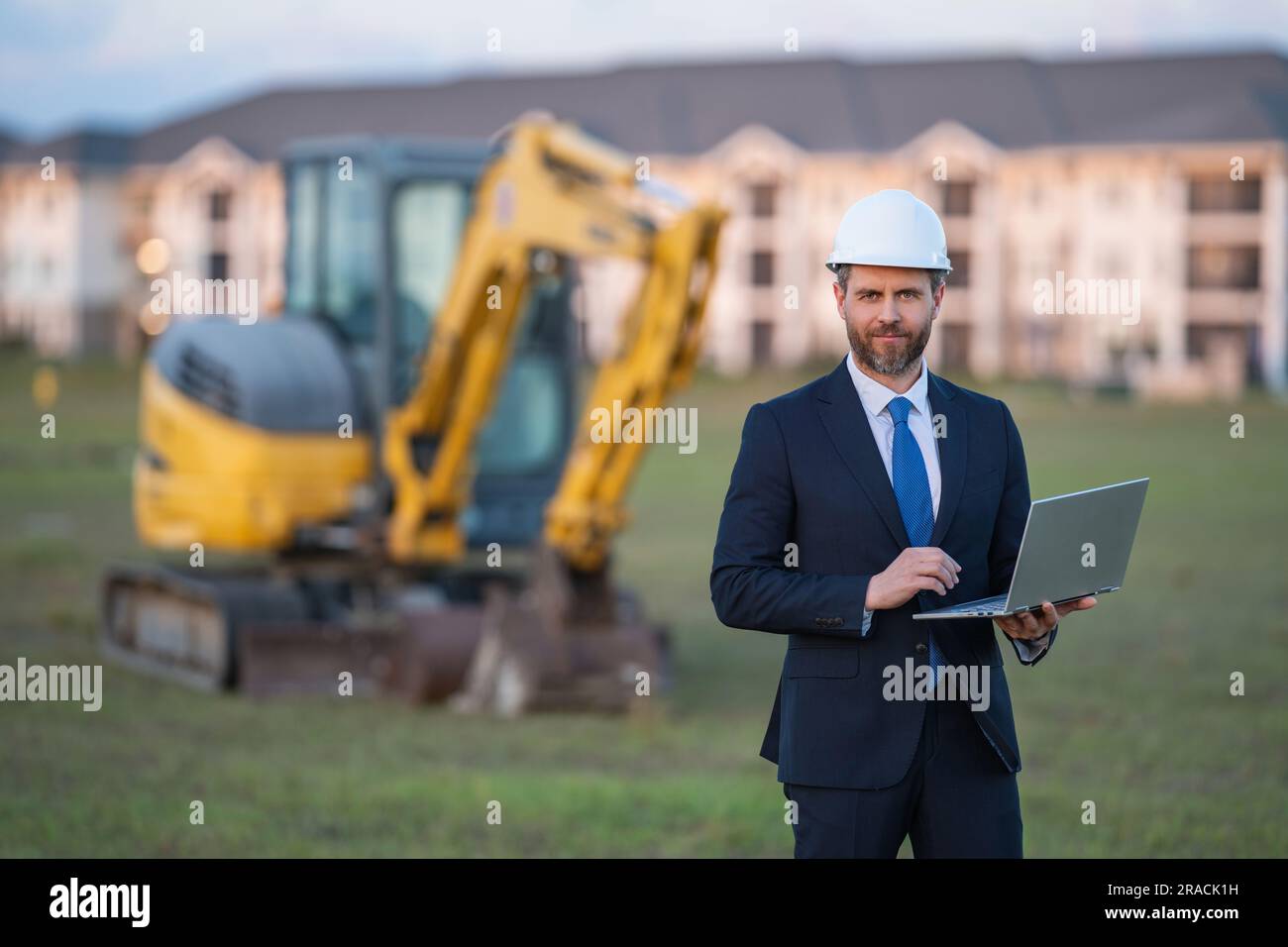 Architect at a construction site. Architect man in helmet and suit at ...