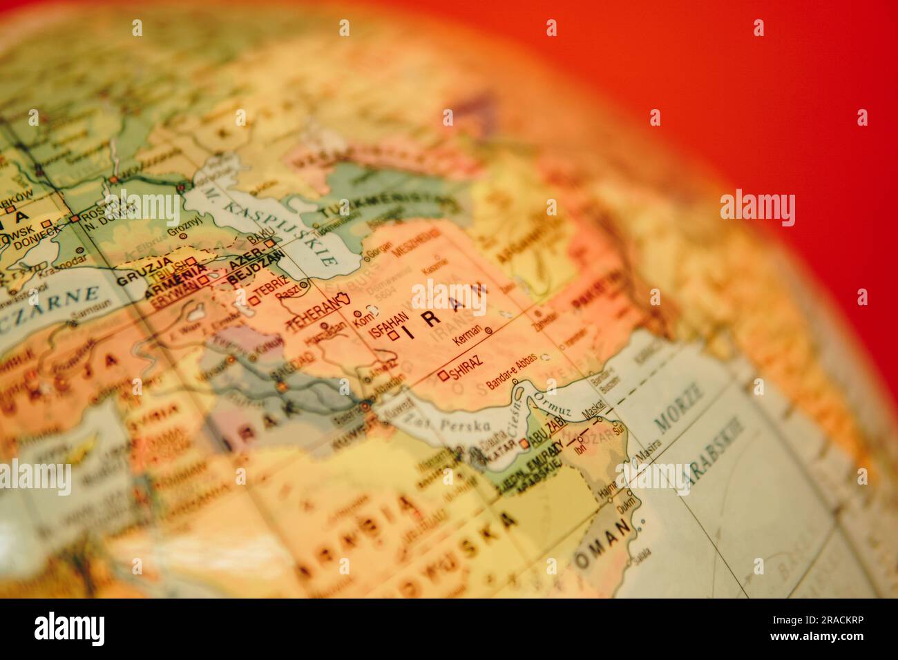 detail of iran on a globe model with political map on the red ...