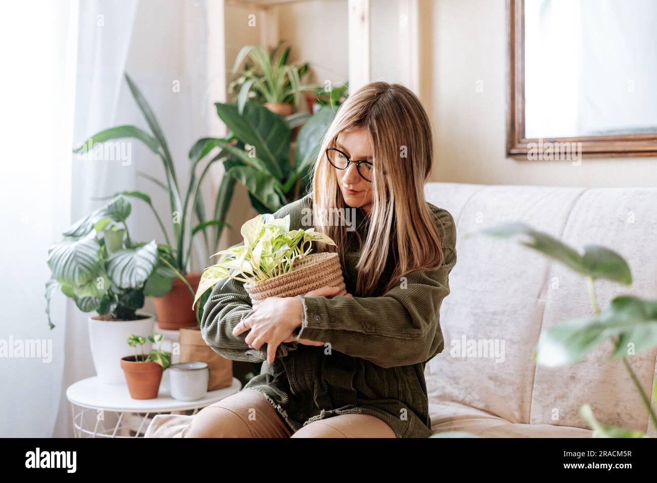 Freelance woman gardener in glasses holding and hug wicker basket with ...