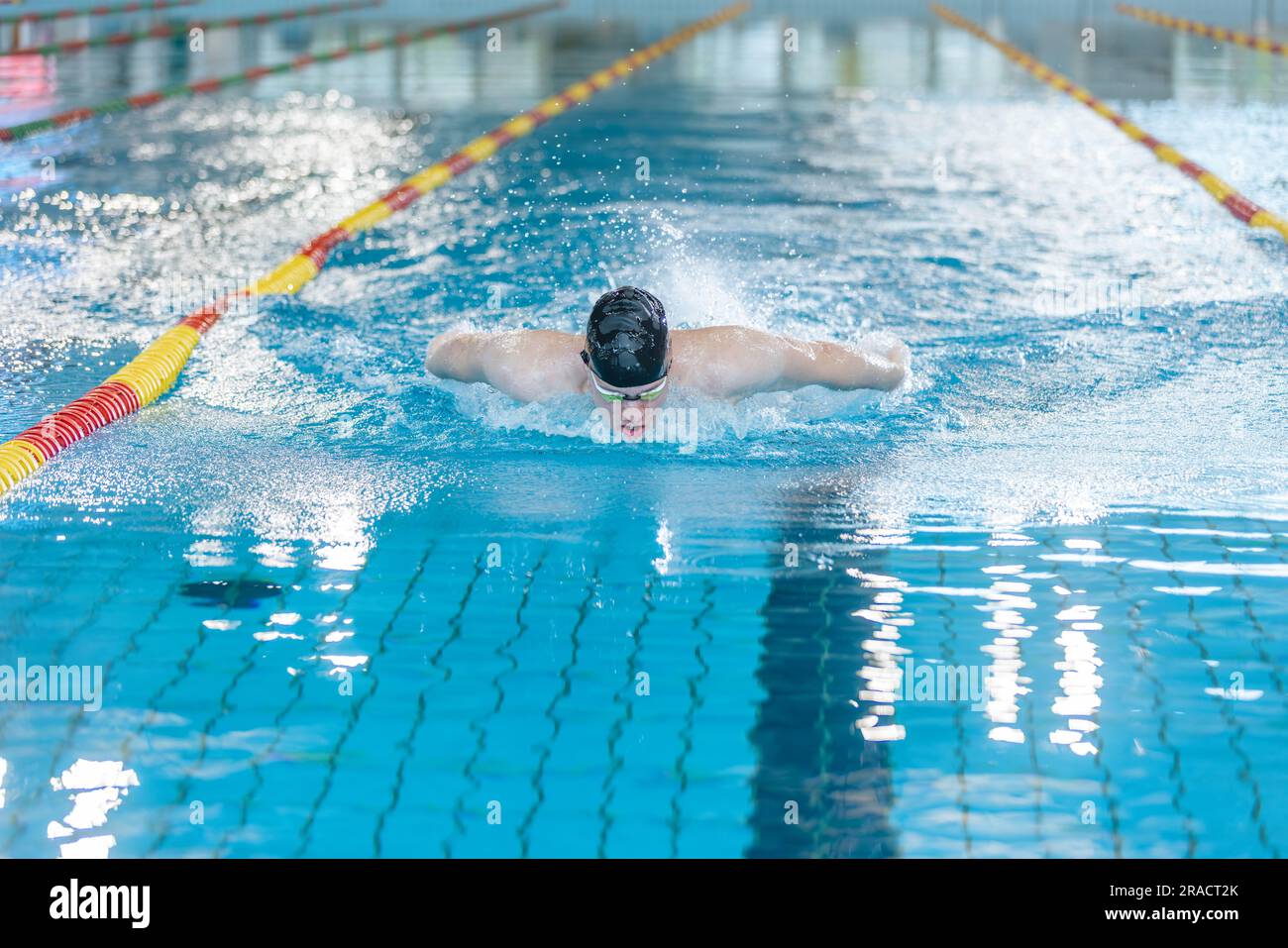 Front view of a female swimmer swimming butterfly style, a stroke ...