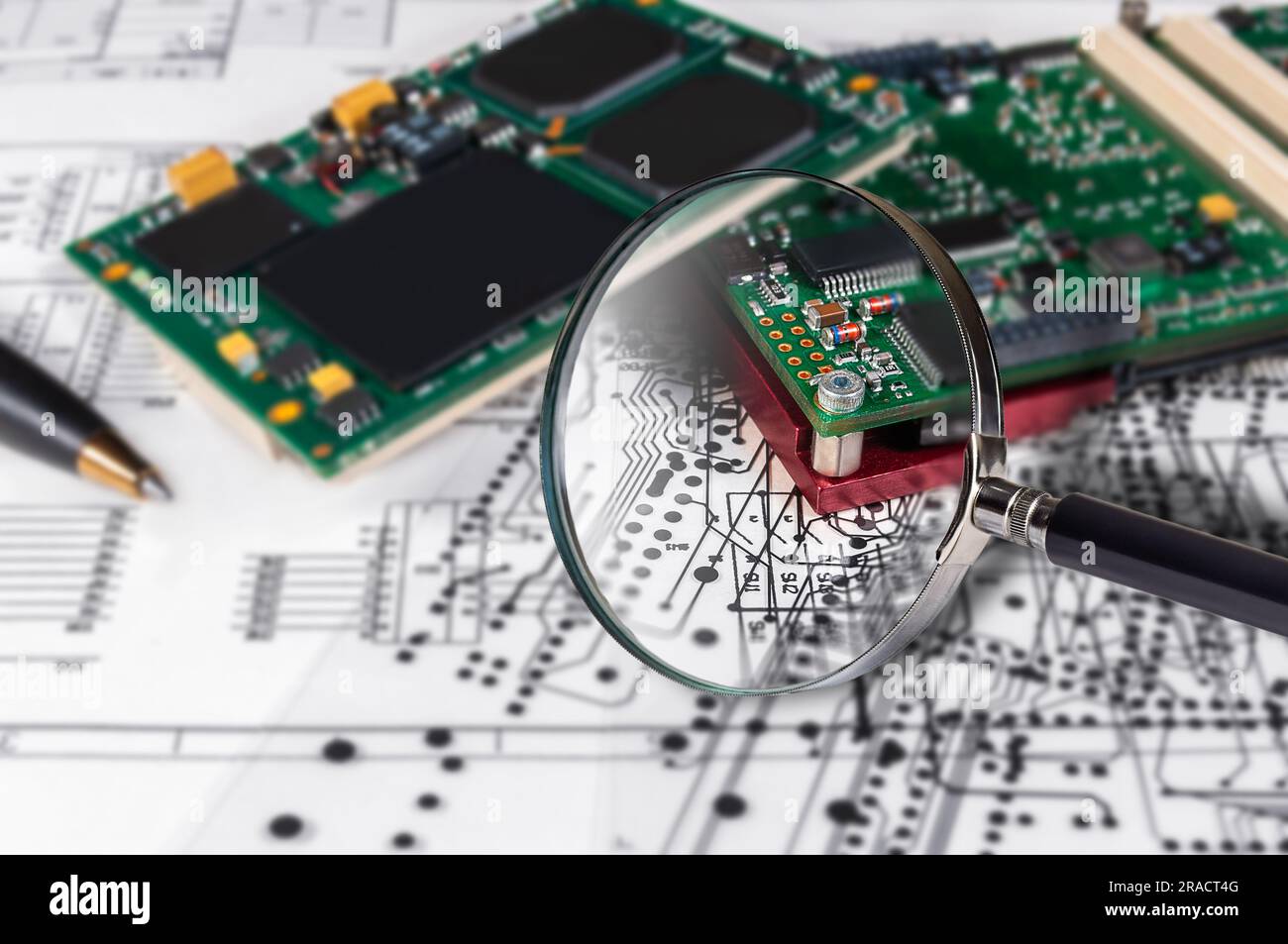 Electronic modules, magnifying glass and pen on background of schematic ...
