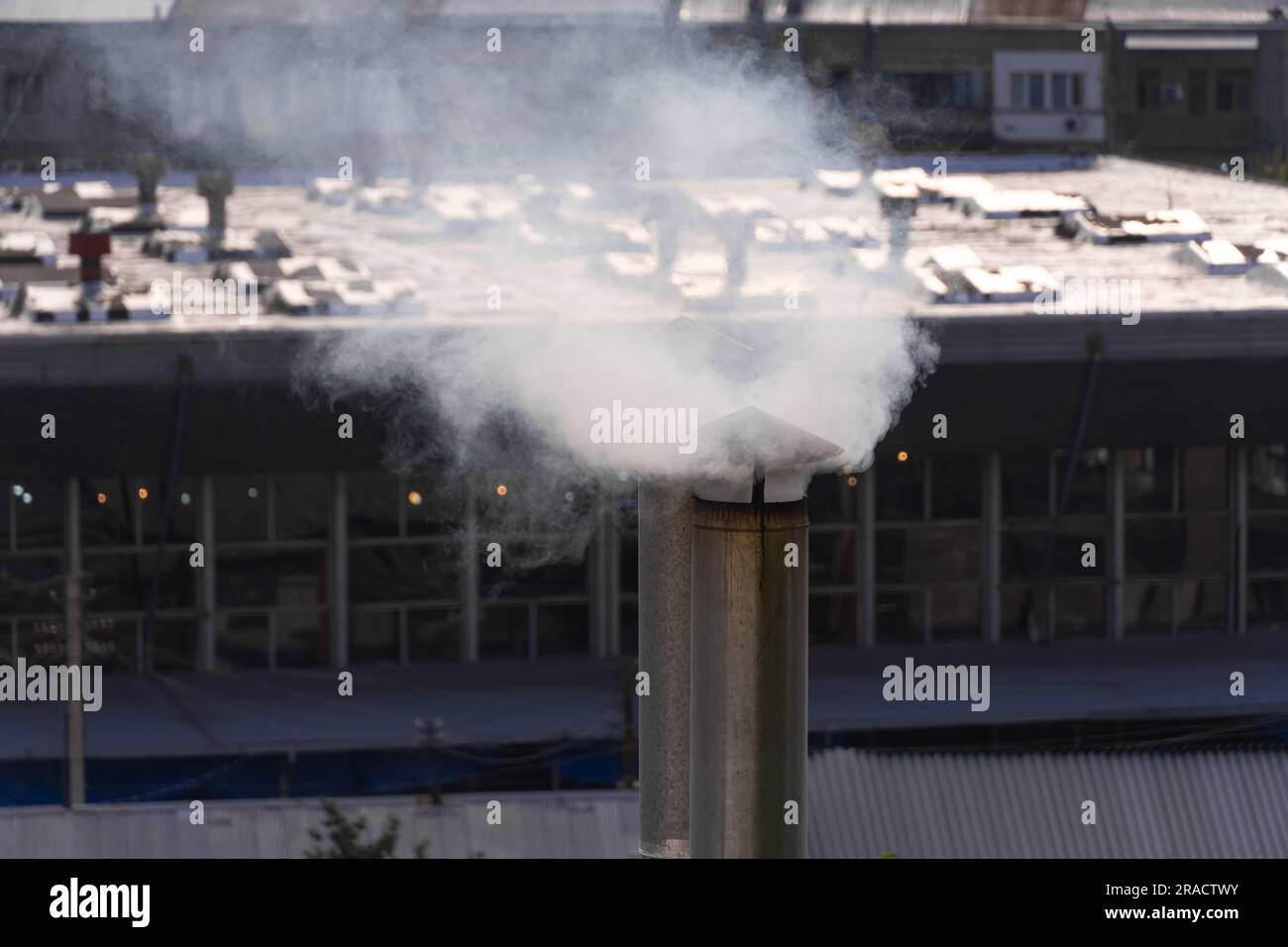 Close-up of smoking tin pipes against the background of industrial ...