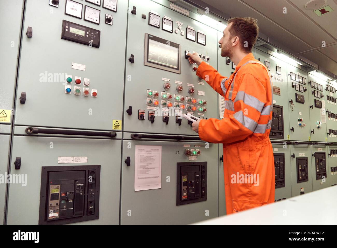 Young professional engineer working on electrical high voltage switch ...