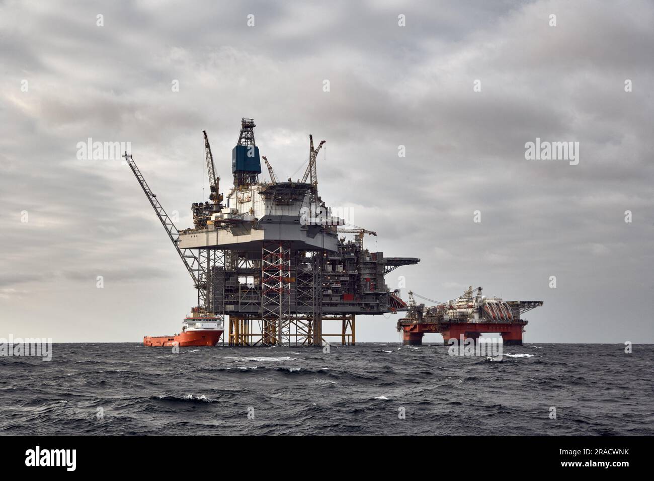 Offshore oil and gas platform with supply vessel doing cargo operations ...