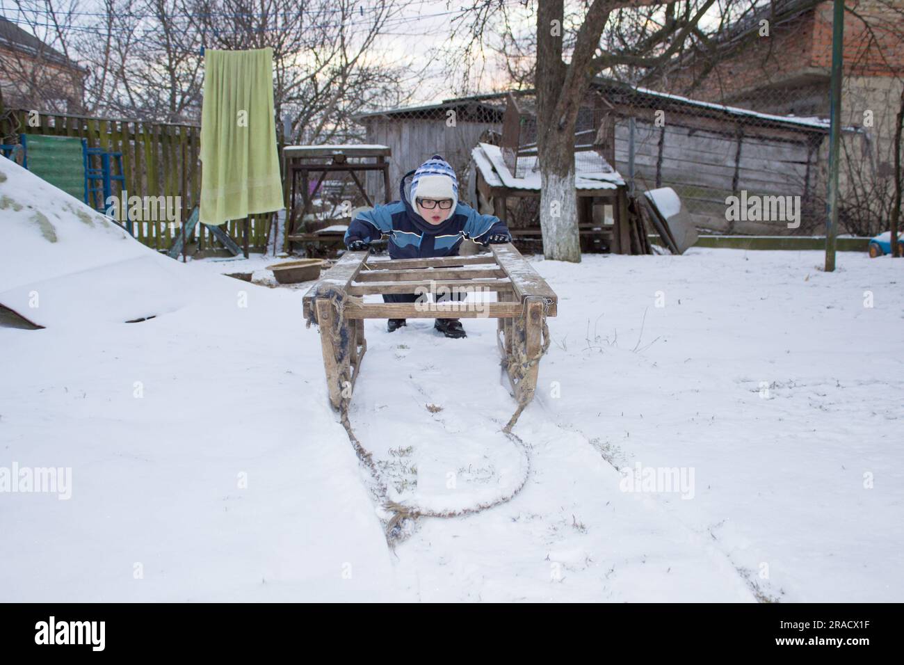 boy in winter pushes a large wooden sledge Stock Photo - Alamy