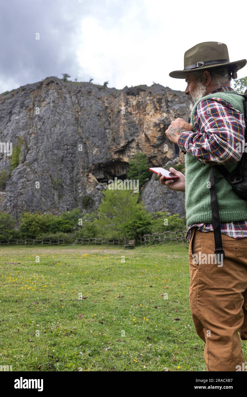 Male Adventurer Backpacker Using Smart phone On Top Of A Valley Stock ...