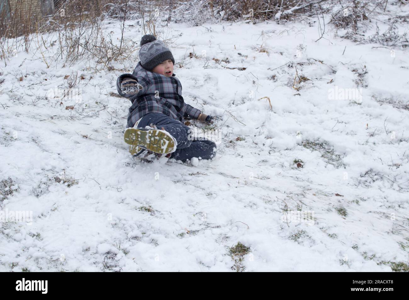 happy boy riding his legs and buttocks in the winter on snow Stock ...