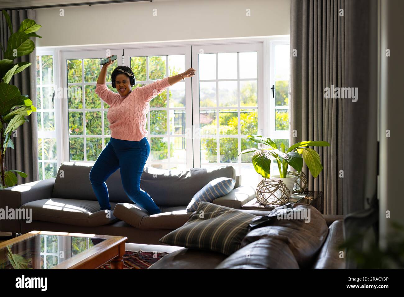 Happy Plus Size African American Woman With Headphones And Smartphone