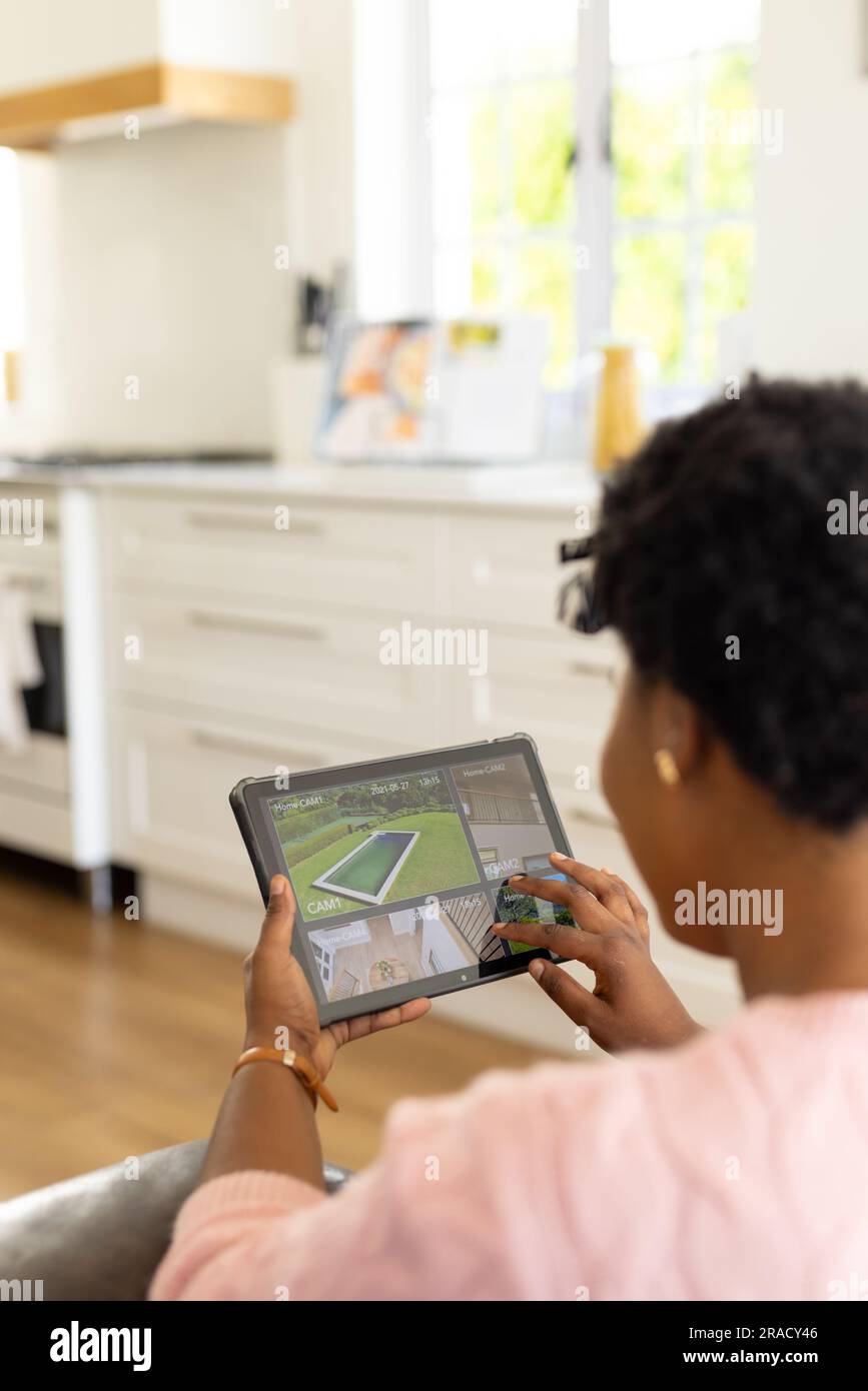 Plus size african american woman using tablet with home security camera ...
