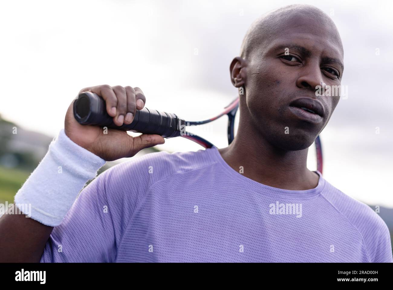 Portrait of serious african american male tennis player holding tennis ...