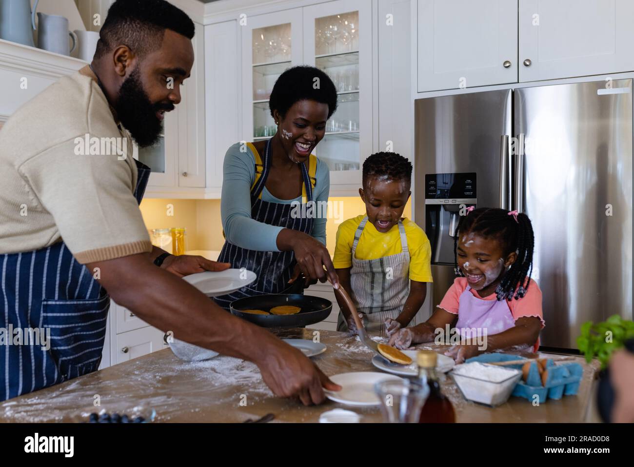 Cheerful african american parents serving pancakes to playful children ...