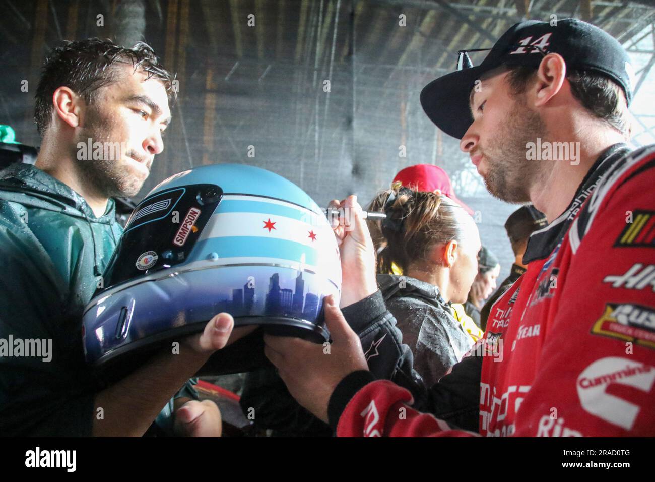 NASCAR drivers autograph some helmets while rain delays the start of ...