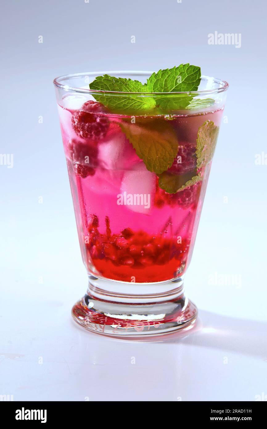 Cocktail with iced tea, pomegranate seeds and raspberries Stock Photo ...