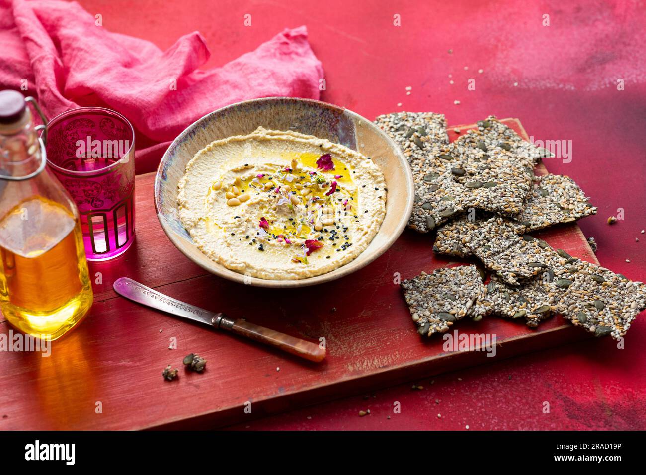 Hummus with pine nuts and multi-grain and seed crackers Stock Photo - Alamy