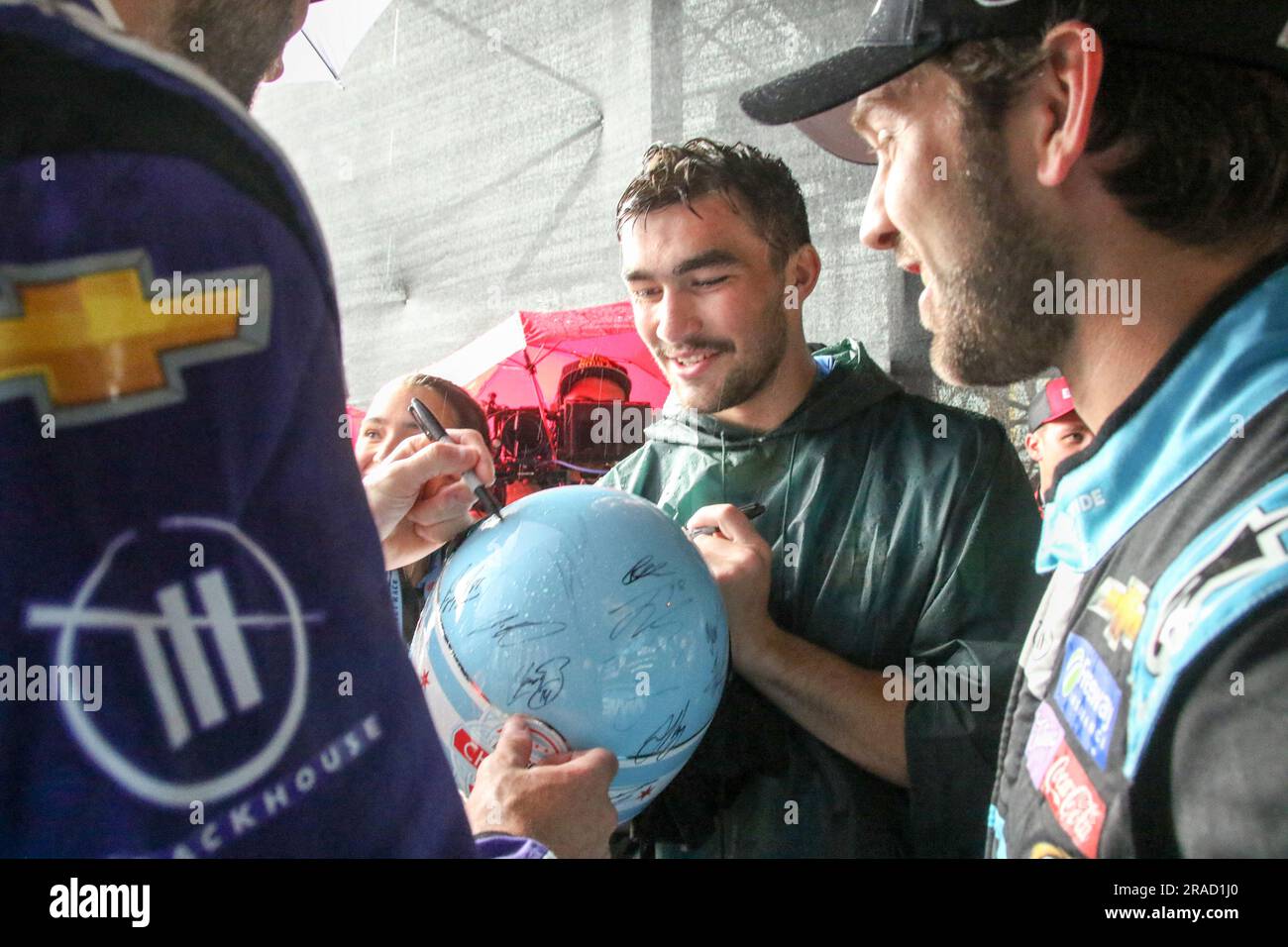 NASCAR drivers autograph some helmets while rain delays the start of ...