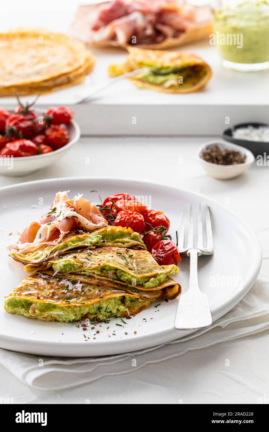 Savoury crêpes with prosciutto, tomatoes and avocado cream Stock Photo ...