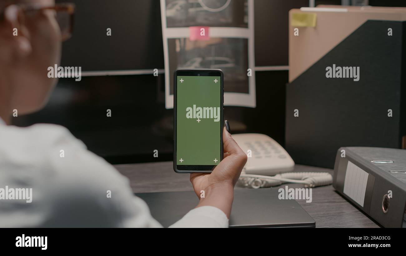 Private detective holding smartphone with greenscreen, policewoman ...