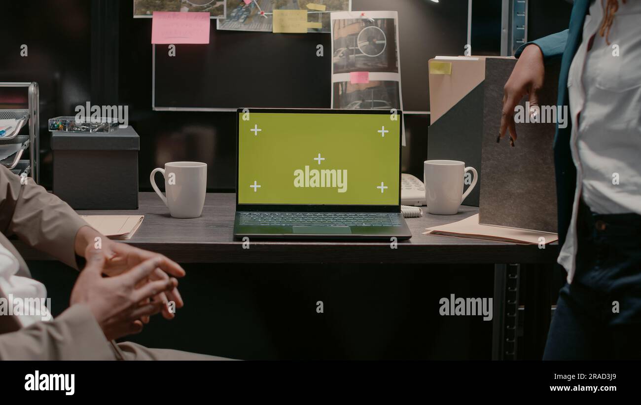 Man and woman working with greenscreen on pc, sitting in evidence room ...