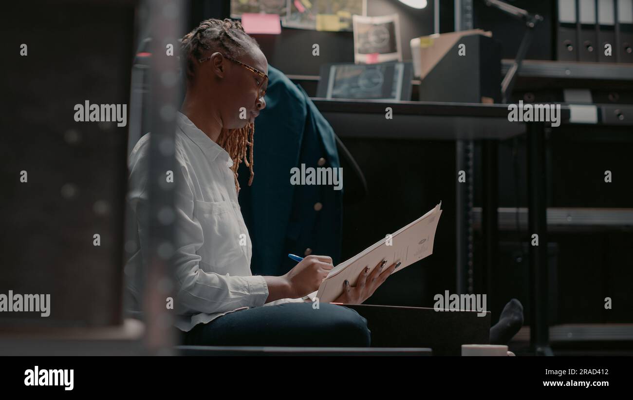 Young investigator checking profile of suspect in incident room ...