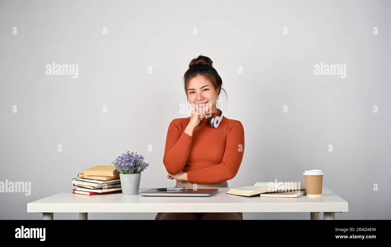 Young adorable college student sitting at her study desk, white ...