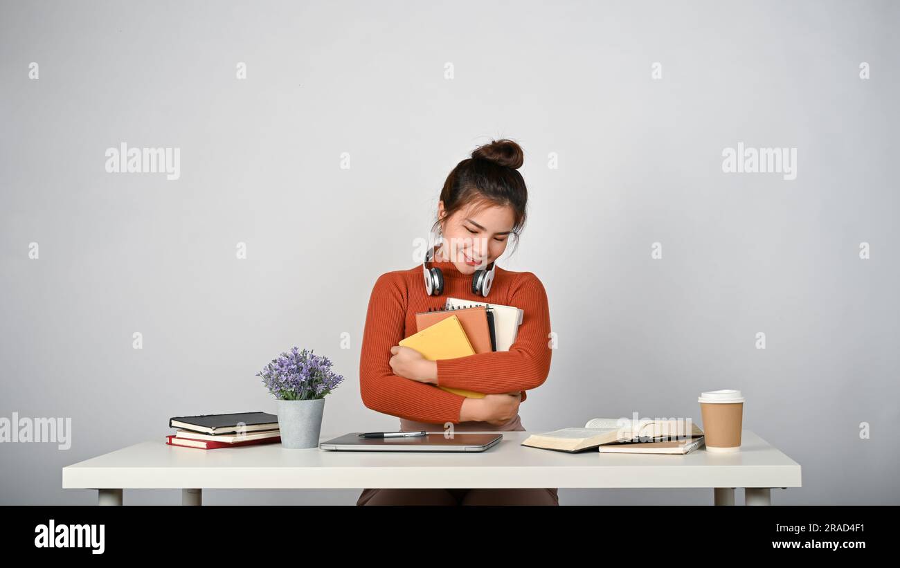 Young adorable college student sitting at her study desk, white ...