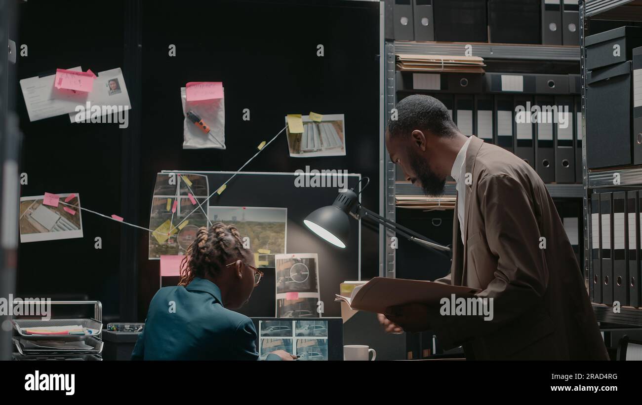 Partners checking evidence photos on detective map and searching ...