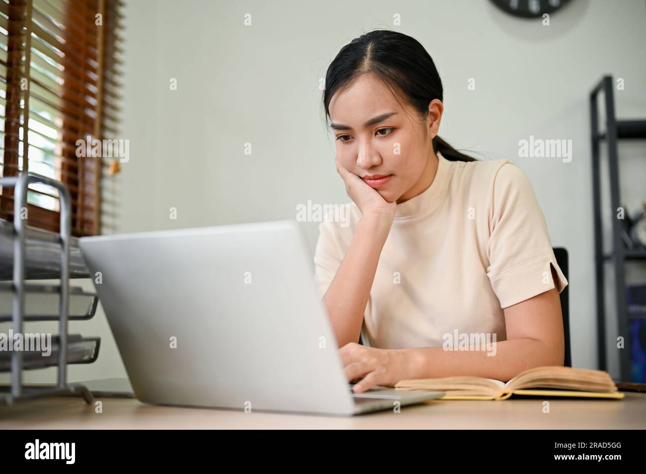 Overworked Asian female woman feeling tired working with laptop ...