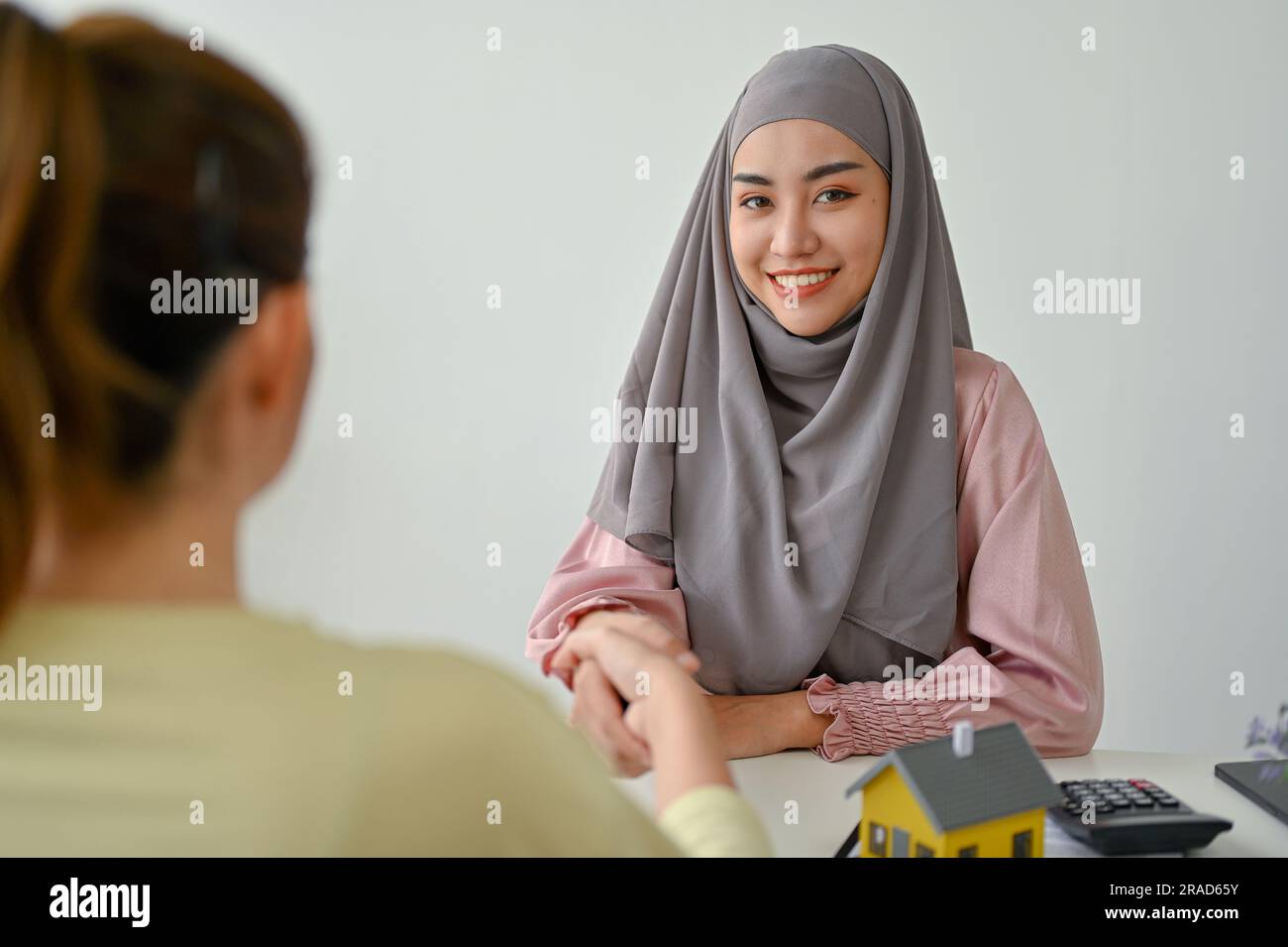 Successful Deal. Muslim real estate agent having a hand shake with her ...