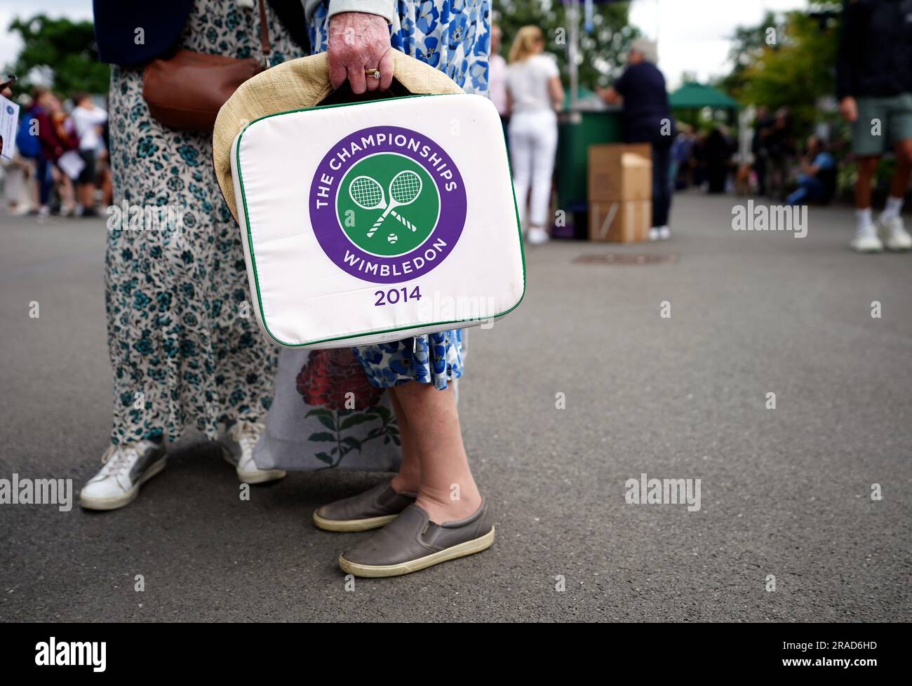 A spectator with a Wimbledon branded cushion on day one of the 2023 ...